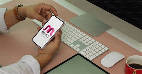 디지털 장치와 커피 컵이 있는 사무실 책상에서 모형 스마트폰을 사용하는 남성 손의 자른 샷 사진 Unsplash의 태국 이미지