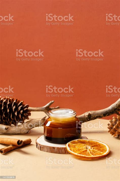 둥근 나무 통나무 연단에 모이스처 라이저의 호박색 유리 항아리 자연 미용 제품 디자인 브랜딩 솔방울 코니퍼 방울에 대한 스톡 사진 및 기타 이미지 Istock