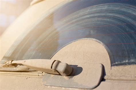 자동차의 리어 윈드 실드 클리너 제대로 청소 먼지와 국가 도로에 위험한 운전에 기여 먼지와 먼지 전면과 배경 배경은 보케 효과와 흐리게 0명에 대한 스톡 사진 및 기타