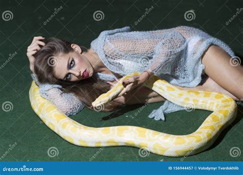 Sexy Young Woman Posing With Albino Python Against Green Background