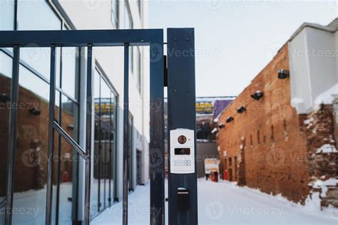 Modern Black Metal Gate With Intercom System On Brick Building