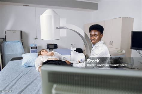 현대 중심의 신장과 요관 돌을위한 리소트립시 전문 아프리카 남자 의사 초음파 검사를 사용하여 여성 환자를위한 석상 전에 돌 위치를 결정합니다 X 레이에 대한 스톡 사진 및