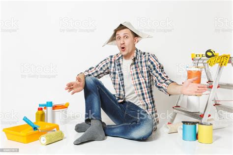 재건축 아파트 룸 흰색 배경에 고립에 대 한 악기와 함께 바닥에 앉아 신문 모자에 혼란된 충격된 남자 벽지 액세서리를 붙이기