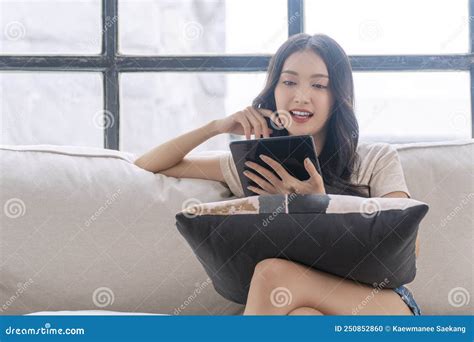 Freelance Asian Woman Surfing Browser With Tablet Sitting With Pillow