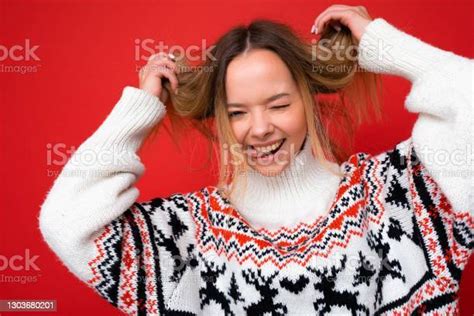 사진 촬영 의 젊은 아름다운 미친 미친 재미 행복 금발 여자 입고 겨울 스웨터 고립 된 빨간 배경 과 복사 공간 겨울에 대한