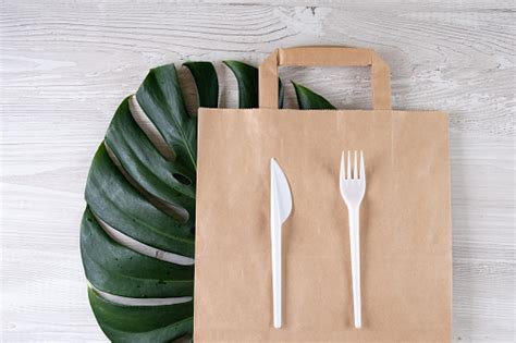 플라스틱 포크 종이 봉투에 칼 복사 공간이 있는 회색 배경에 친환경 식품 포장 및 면 에코 백 자연과 재활용 개념의 보살핌 케이터링 및 길거리 패스트푸드용 용기 가방에 대한