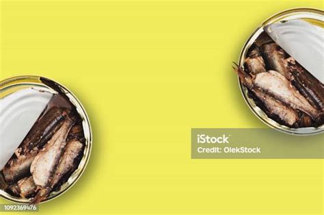 2 요리에 노란 테이블에 기름에 보존 된 물고기와 금속 캔을 엽니다 텍스트에 대 한 공간을 복사 합니다 최고의 볼 수 있습니다 패스트 푸드 나 요리 개념 0명에 대한 스톡