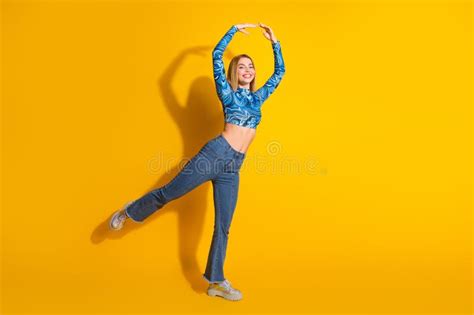 Young Fashionable Woman Performing Playful Pose Against A Bright Yellow