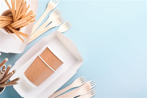 종이 컵 접시 가방 나무 포크 음주 빨대 패스트 푸드 용기 밝은 파란색 배경에 나무 칼붙이 에코 크래프트 종이 식기 재활용 및