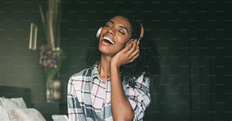 침대에서 헤드폰과 스마트폰으로 음악을 듣는 여자 사진 Unsplash의 머리 이미지