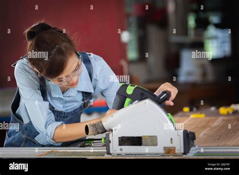 Woman Works In A Carpentry Shop Attractive Female Carpenter Using Some Power Tools For Her Work