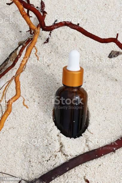 뿌리가 있는 모래에 기름이 든 어두운 호박색 유리병 천연 화장품 제품 아름다움 및 프리젠 테이션 개념 모의 휴식과 휴가 스타일 갈색에 대한 스톡 사진 및 기타 이미지