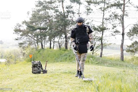 군복과 방탄 조끼를 입은 남자가 금속 탐지기로 숲에서 일합니다 지뢰 찾기는 영토를 제거하는 작업을 수행합니다 35 39세에 대한 스톡 사진 및 기타 이미지 Istock