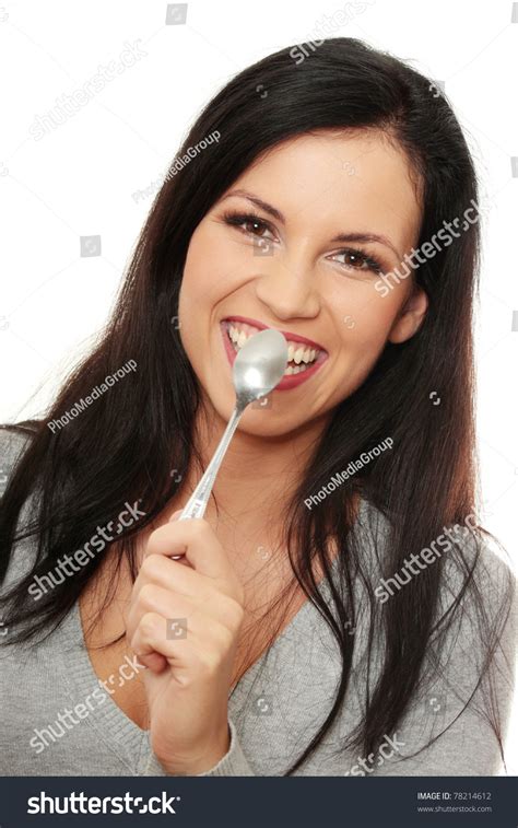 Portrait Of Young Smiling Woman With Spoon In Her Mouth And Pleasure