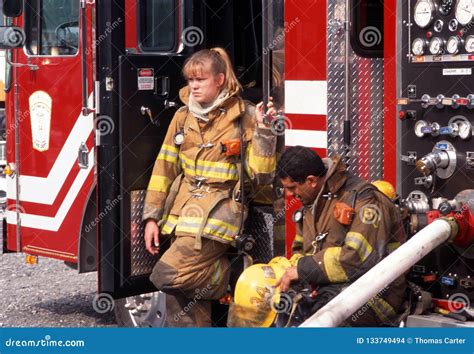 Two Firefighters Take A Break After Fighting A House Fire Editorial