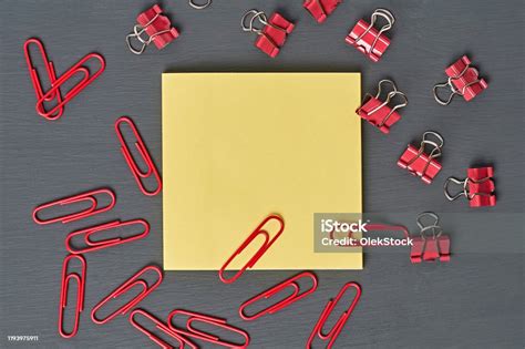 사무실 학교 또는 가정의 어두운 콘크리트 책상에 메모를 위해 빈 사각형 종이 근처에 많은 바인더와 클립을 흩어져 있습니다 텍스트의 공백입니다 맨 위 보기 개성 개념에 대한