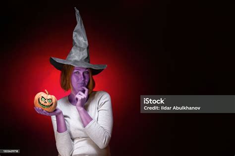 할로윈 검은 마녀 모자에 보라색 피부를 가진 젊은 여성이 좀비 얼굴로 호박을 들고 있다 어두운 빨간색 배경 및 복사 공간 가을에 대한 스톡 사진 및 기타 이미지 Istock