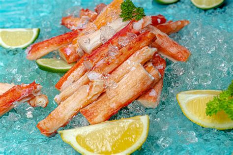 게 고기와 신체 부위 촉수 무릎 큐브 얼음에 푸른 해양 배경 레몬과 라임 의 조각은 녹색 빛 상단 측면보기 주위에 주위에 둥근 슬라이스 갈고리 발톱에 대한 스톡 사진 및