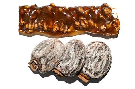 여러 가지 빛깔의 동양 과자 클로즈업 흰색 배경에 Churchkhela와 말린 감 Churchkhela는 포도 주스에 견과류가 든 양초 모양의 전통적인 그루지야 어