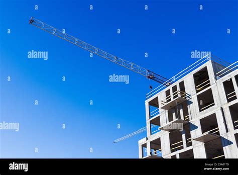 Construction Crane Works Over Modern Concrete House Carcass With Empty