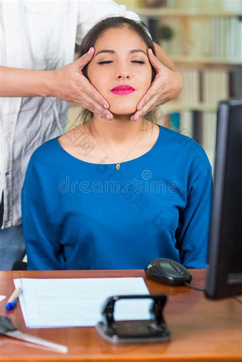 迷人的黑发办公室妇女穿着蓝色毛衣坐在办公图片 包图网企业站