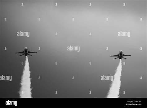 Two Commercial Airliners Soar Through A Bright Blue Sky Leaving