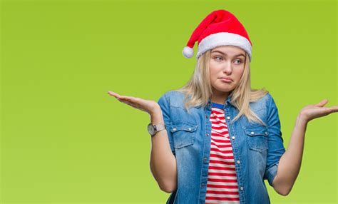 발생 하는 손과 팔으로 고립 된 배경 우 둔 하 고 혼란 스 러 워 식 이상의 크리스마스 모자를 입고 젊은 백인 여자 의심 개념입니다 감정에 대한 스톡 사진 및 기타 이미지