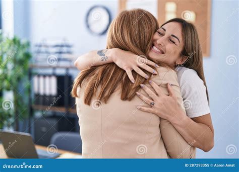 Mother And Daughter Business Workers Hugging Each Other At Office Stock