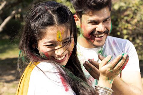 젊은 부부 친구 가족 소년 소녀 남자 여자는 인도 전역에서 인기있는 힌두교 축제 인 공원에서 야외에서 Gulal Abeer 컬러 파우더로 색채의 홀리 축제를 즐기는 것을