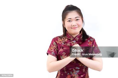 전통적인 중국 긴 복장 Cheongsam 검은 머리 동안에 중국 새 해 축제 축 하 중국 스타일의 손 인사와 함께 멋진 미소에