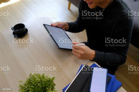 바닥에 앉아있는 동안 디지털 태블릿에 쓰기 스타일러스 펜을 사용하여 젊은 남자의 자른 샷 20 24세에 대한 스톡 사진 및 기타 이미지 20 24세 공란 남성