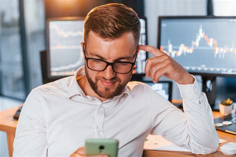 손에 전화로 정장 옷을 입은 젊은 사업가가 여러 개의 스크린으로 사무실에 있습니다 25 29세에 대한 스톡 사진 및 기타 이미지 25 29세 그래프 금융 Istock