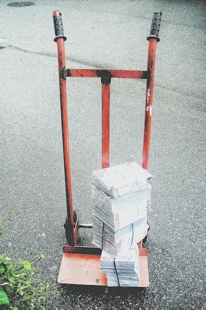 Premium Photo High Angle View Of Push Cart With Newspaper Stack On Road