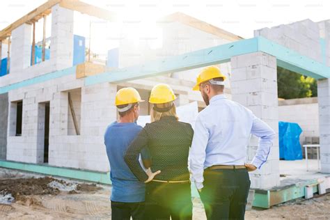 건축가 토목 기사 노동자가 계획과 청사진을 보고 건설 현장에서 문제를 논의합니다 사진 Unsplash의 주택 개발 이미지