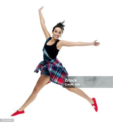 전체 길이정면 보기1819세 성인 의 카메라를 보고 아름 다운 흑발긴 머리포니테일 코 카 서 스 여성젊은 여성 점프공중 에서 흰색 배경 착용 턱받이 바지를 들고 팔을 들어