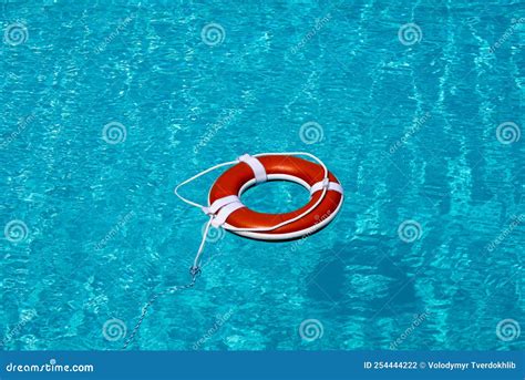 Lifebelt On Sea Or Pool Orange Inflatable Ring Floating In Blue Water Life Buoy For Protect