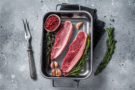 프라임 생 탑 등심 쇠고기 또는 캡 럼프 스테이크가 허브를 곁들인 트레이에 놓입니다 회색 배경 위쪽 보기 0명에 대한 스톡 사진 및 기타 이미지 Istock