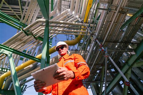 남자 작업자 엔지니어가 데이터 관리를 위해 태블릿을 사용하여 가스 및 오일 석유 산업의 산업 시설에서 현장 검사를 수행합니다 운영 유지를 위한 기술 및 안전성 Brand