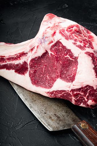 향신료 문지르기와 함께 굽는 재료가있는 생 토마호크 쇠고기 스테이크와 검은 돌 배경에 오래된 정육점 칼 꽃등심 스테이크에 대한 스톡 사진 및 기타 이미지 Istock