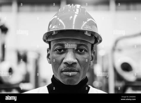 African Engineer Working Inside Robotic Factory Focus On Face Black And White Editing Stock