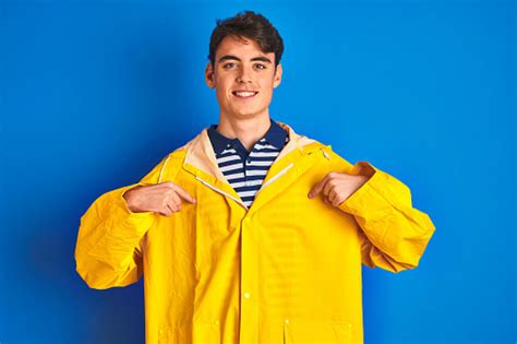 고립 된 배경에 노란색 비옷을 입은 십대 어부 소년은 얼굴에 미소를 지으며 자랑스럽고 행복한 손가락으로 자신을 가리킵니다 가리키기에 대한 스톡 사진 및 기타 이미지 Istock