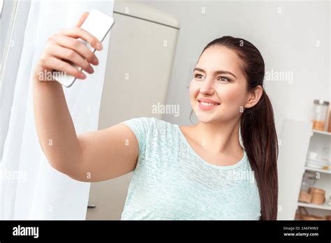 Body Care Chubby Girl Standing In Kitchen Taking Selfie On Smartphone