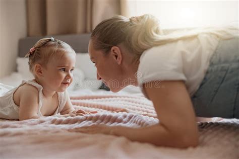 Madre Joven Sonriendo Y Jugando Con Su Bebé Mientras Está Tumbada En La