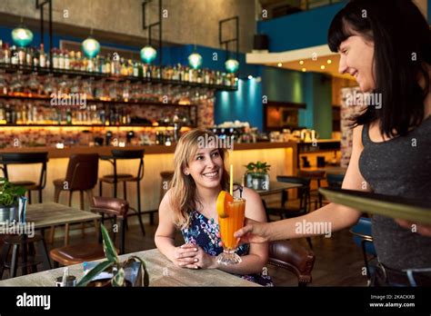 She Loves Making Customers Happy A Young Waitress Serving A Drink To A