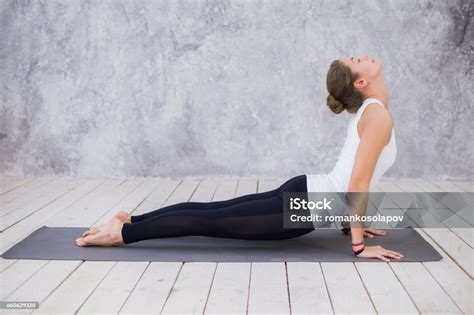 아름 다운 젊은 여자 실내 운동 흰 벽과 방에 요가 운동을 하 고 아래로 직면 개 포즈 Adho Mukha Svanasana 태양 인사말 포즈 전체 길이 측면 보기 20