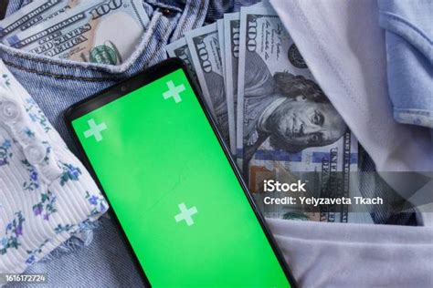 주머니에 미국 달러가 든 청바지 녹색 화면 평면도가 있는 스마트폰 Brand Name Smart Phone에 대한 스톡 사진 및