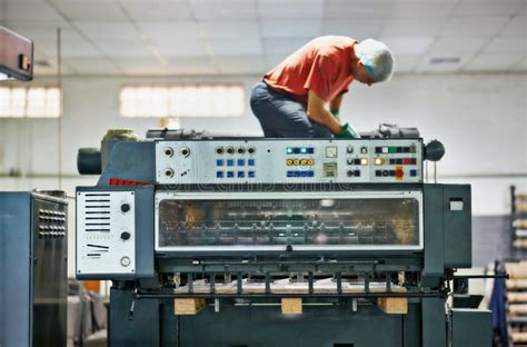 Maintenance Equals Efficiency A Machine In A Factory With A Man Working On Top Of It Stock