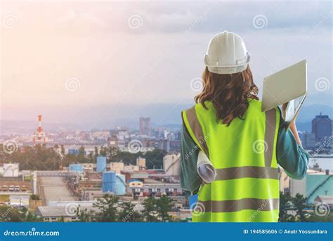 Female Civil Engineer In Safety Hard Hat With Blueprint Paper While