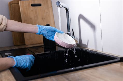 부엌 싱크대에서 하얀 그릇을 씻는 사람 흐르는 물과 주방 용품이 있는 일상적인 가정 활동을 엿볼 수 있습니다 가정 생활에 대한 스톡 사진 및 기타 이미지 Istock