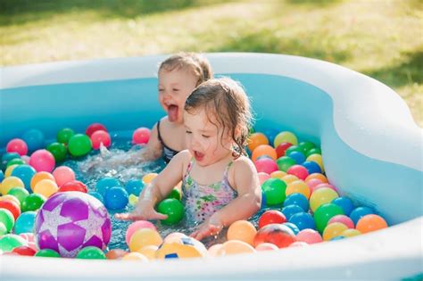 As Duas Meninas Brincando Com Brinquedos Na Piscina Inflável No Dia